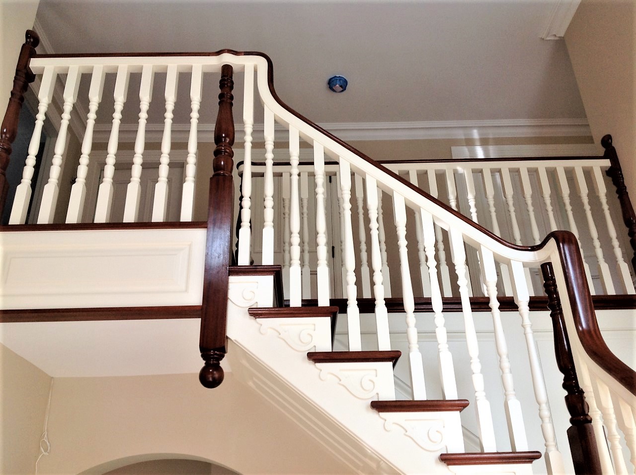 Mahogany and ivory cut string stairs with continuous handrail and wall ...